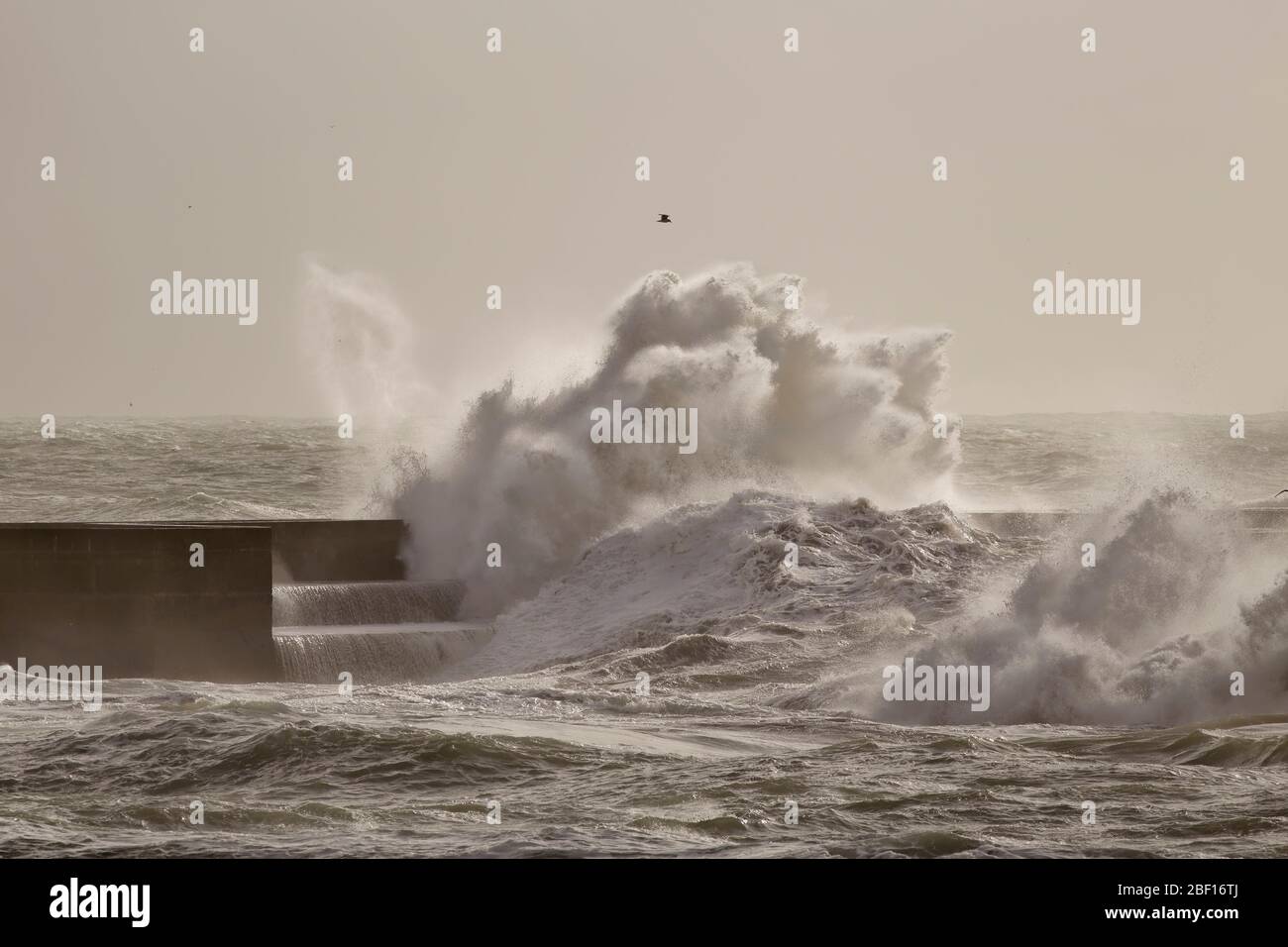 Big wave splash against pier and beacon Stock Photo - Alamy