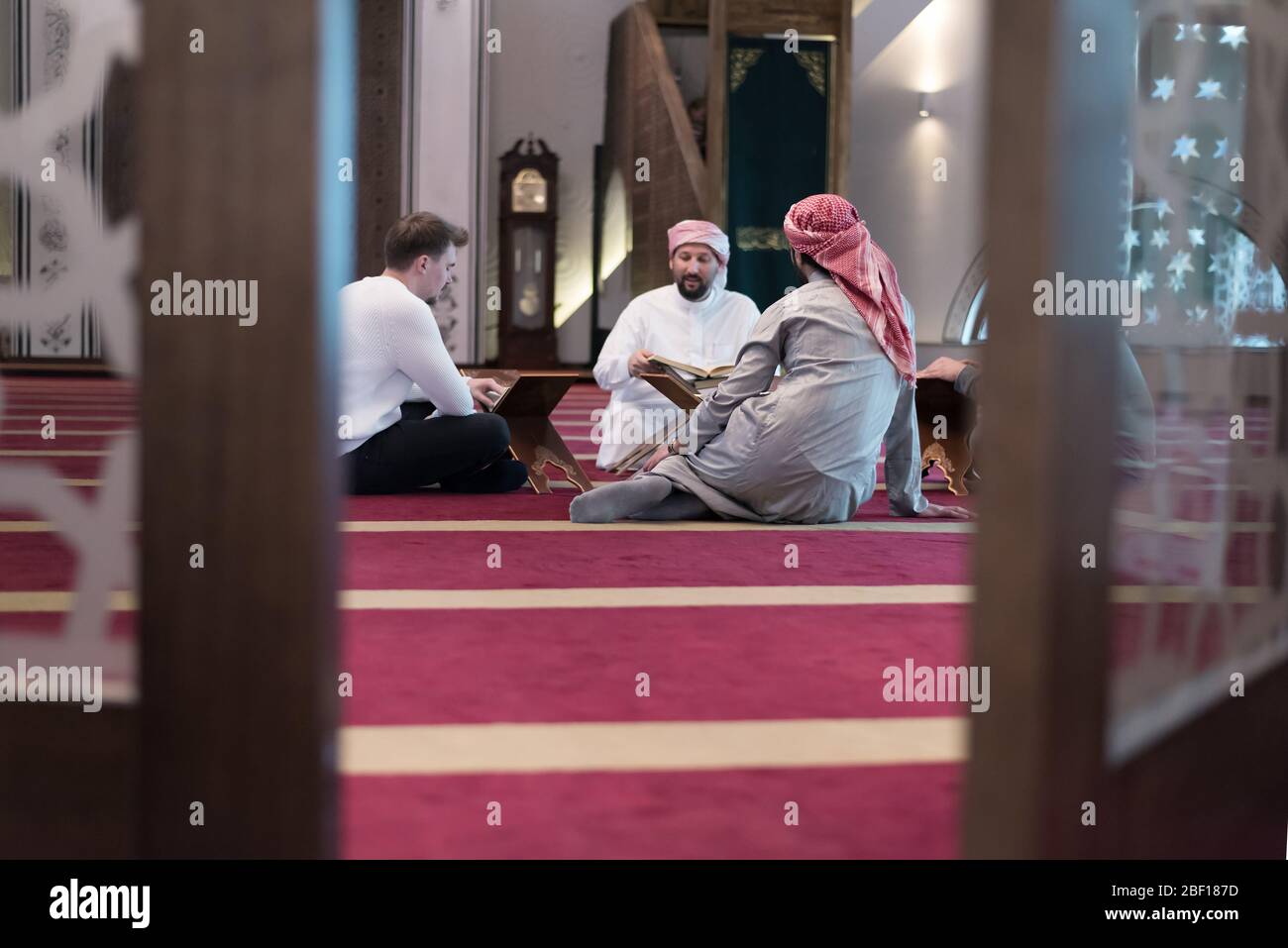 Group of muliethnic religious muslim young people praying and reading ...