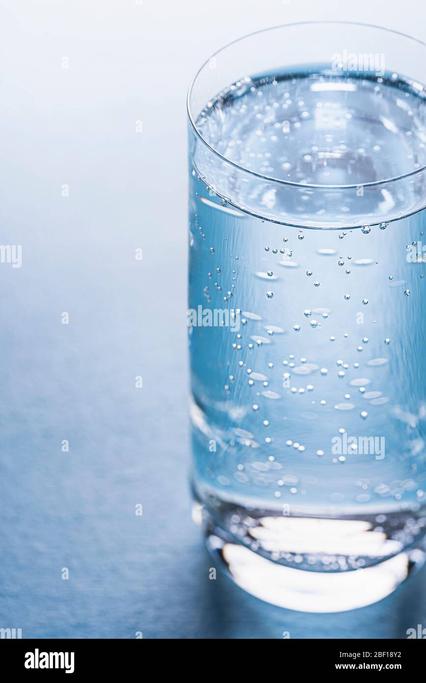 Cold tonic water in a glass, reflecting the blue color from the ...