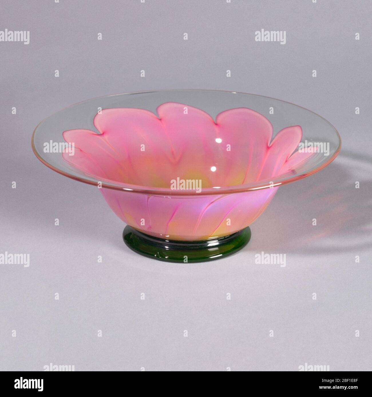 Bowl. Clear glass bowl with flared rim showing ten pink petals with ...
