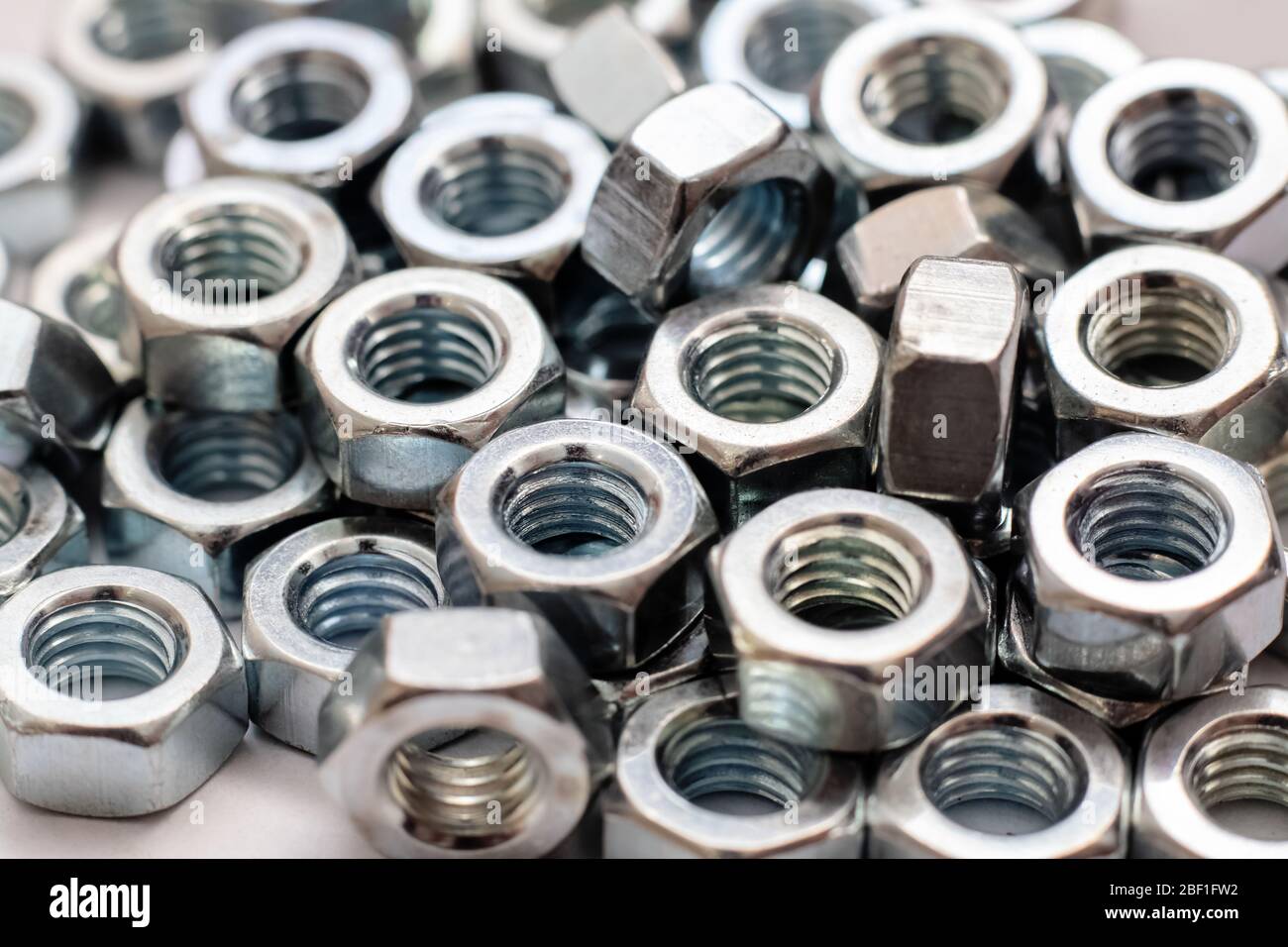 Bunch of new metal nuts background or texture Stock Photo - Alamy