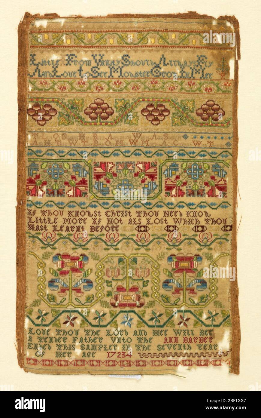 Sampler. Floral embroidery separating areas of text. Top text reads ...