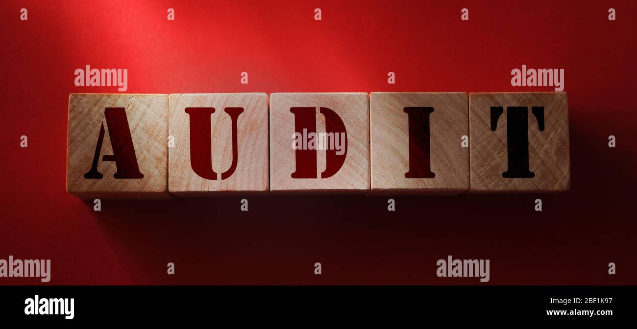 AUDIT word written on wooden blocks on red background. Financial ...