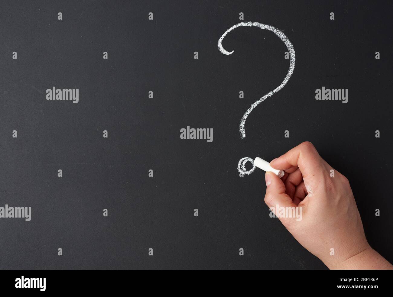 hand typed with white chalk a question mark on a black chalkboard, copy ...
