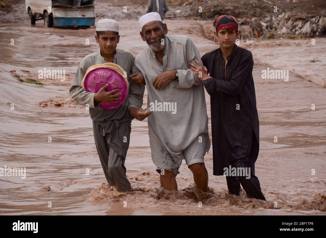 April 16, 2020: Peshawar, Pakistan.: Residents wade through floodwater ...