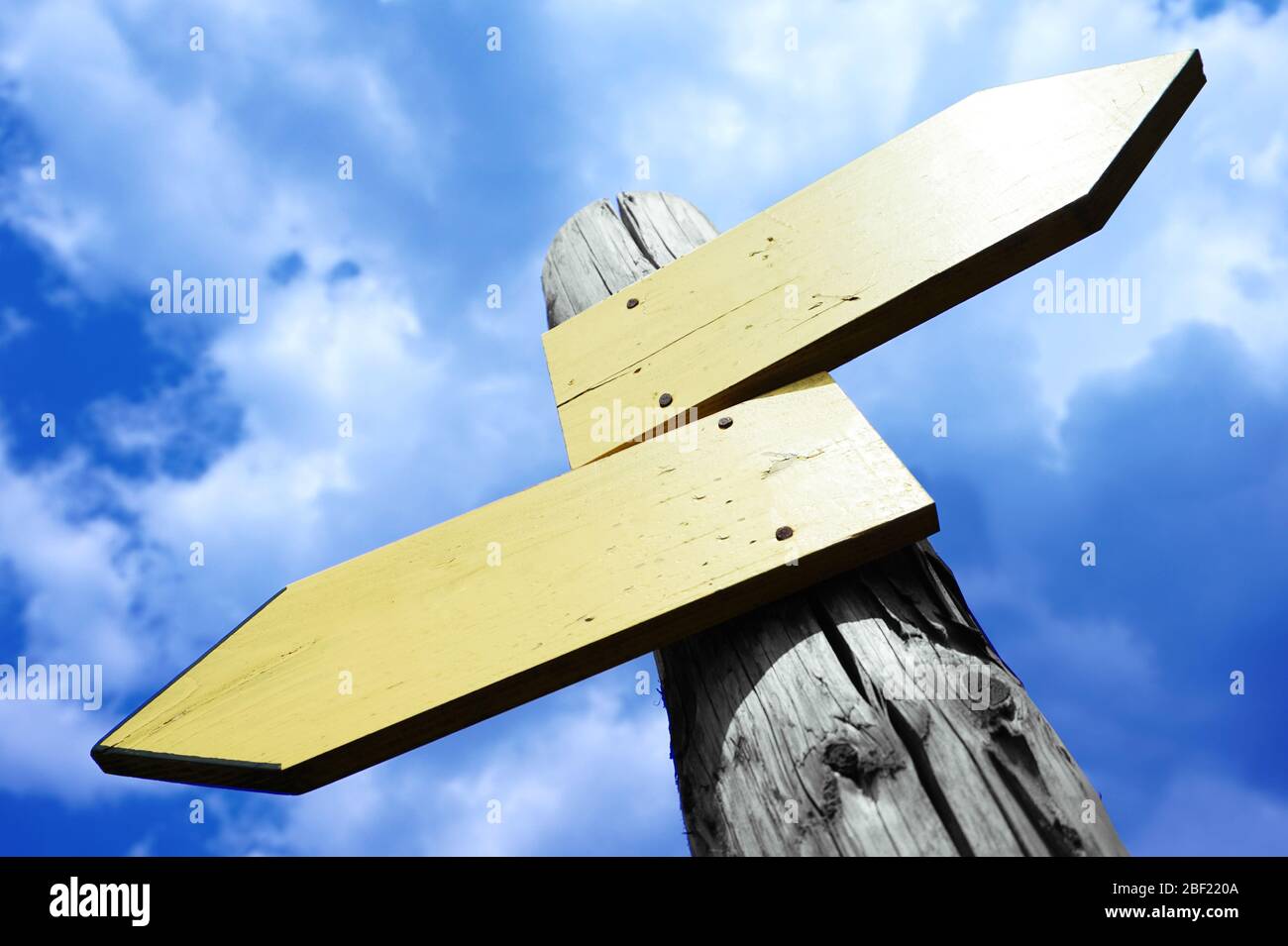 Empty wooden signpost with two arrows Stock Photo - Alamy
