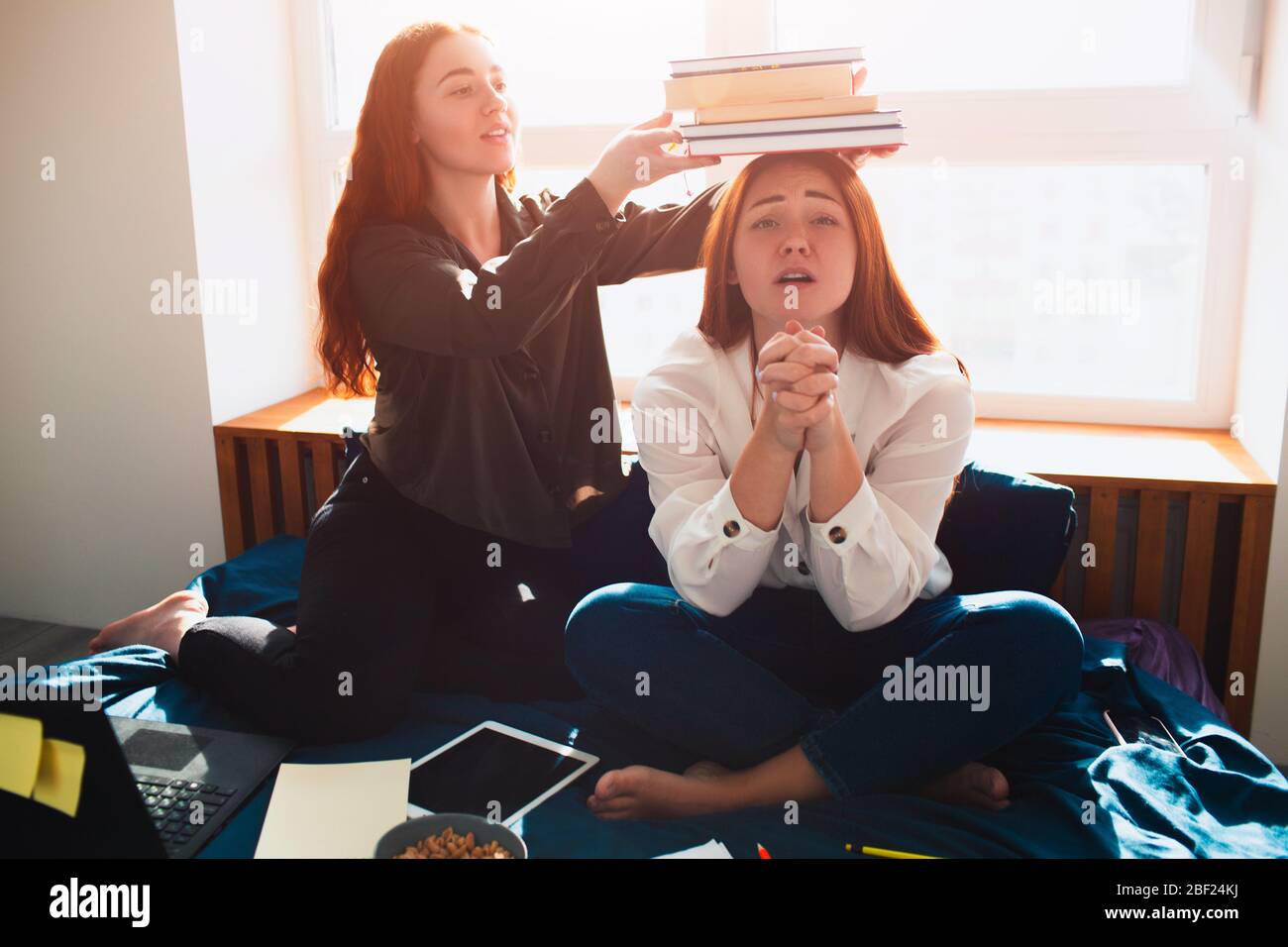 Heavy learning concept. One student put a young woman on her head with ...
