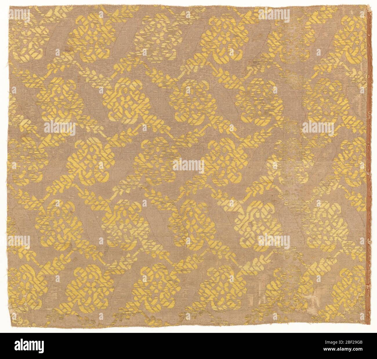 Textile. Woven textile showing a yellow floral pattern on a metallic ...