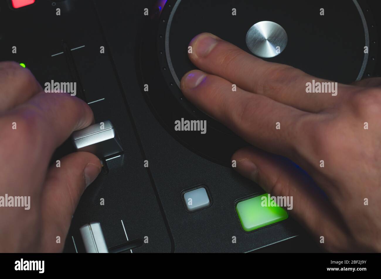 DJ plays music. sound mixer controller with knobs and sliders close up ...