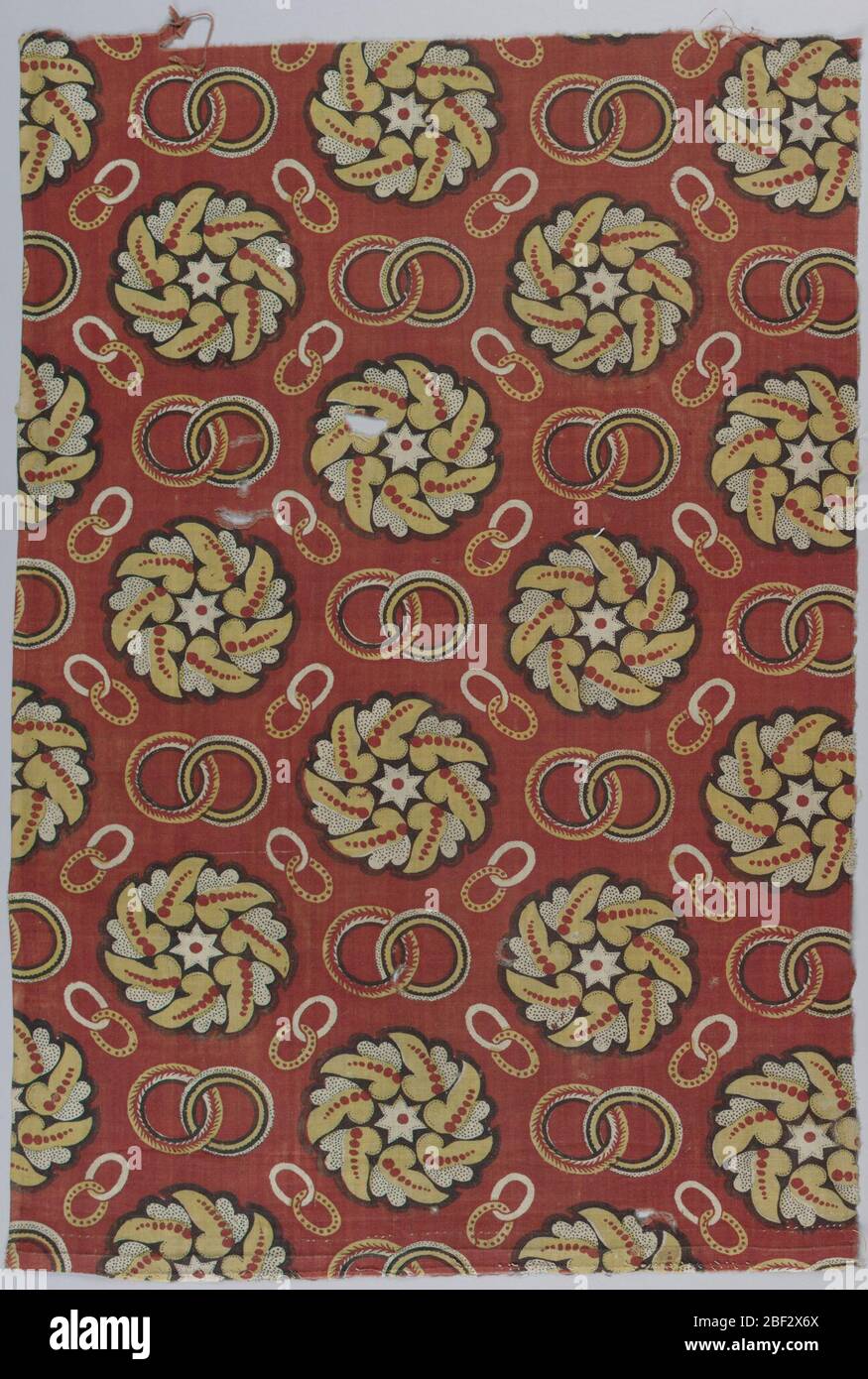 Textile. Red ground with a staggered repeat of whirling rosettes in ...