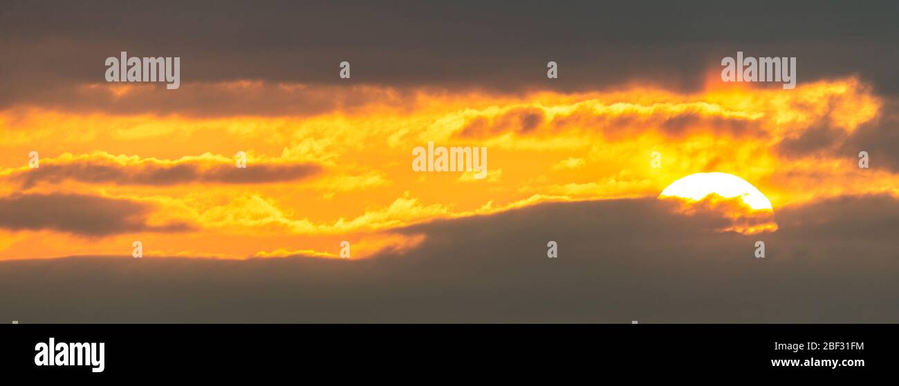 Big orange Sun is rising behind heavy clouds Stock Photo - Alamy