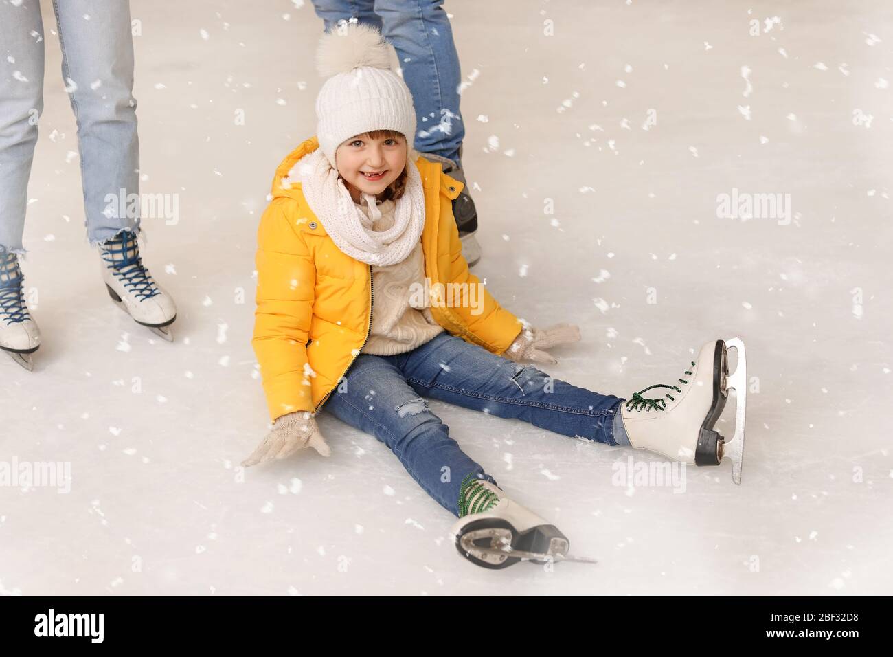 Cute little girl after falling on skating rink Stock Photo - Alamy