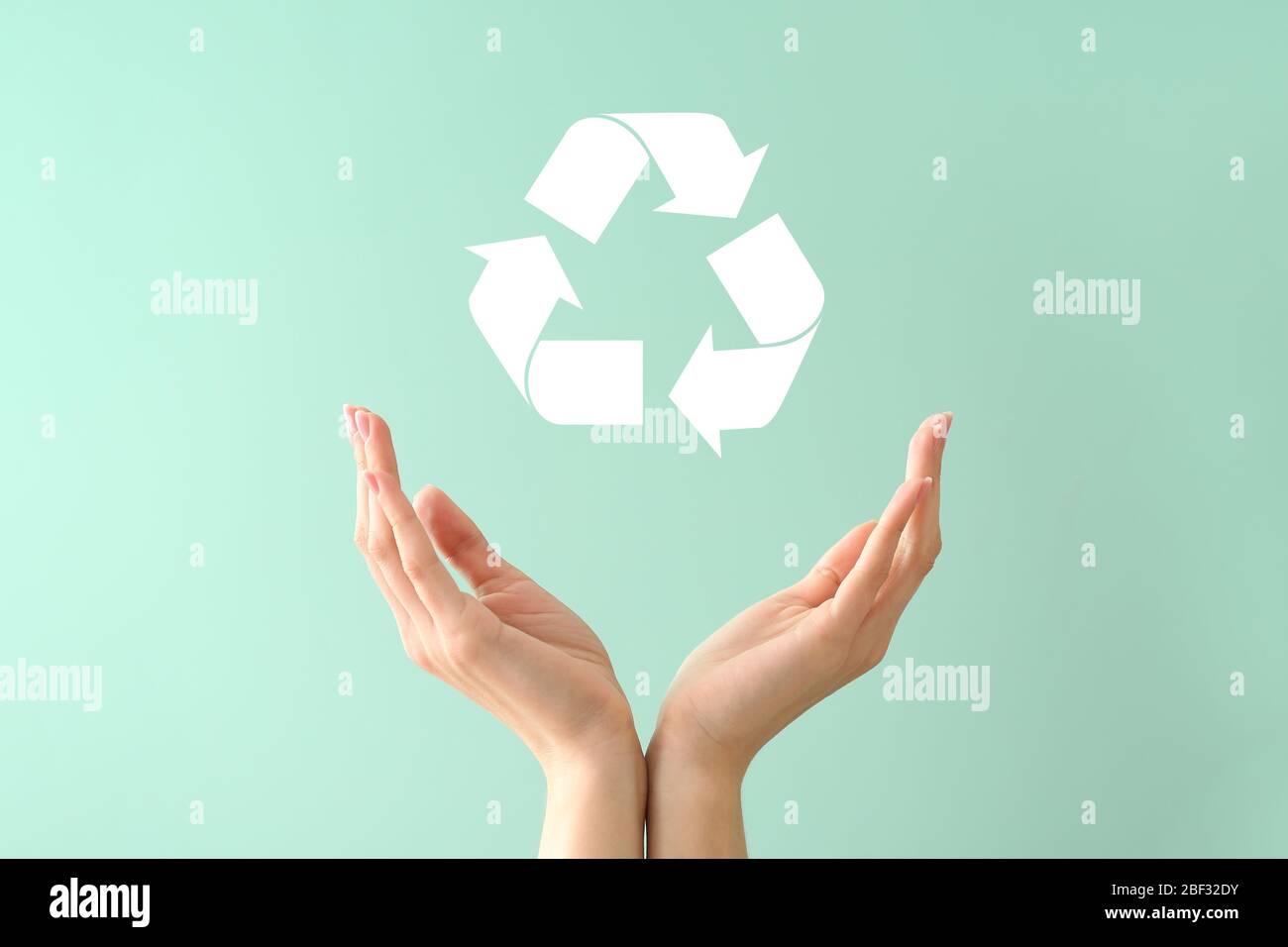 Female hands and symbol of recycling on color background Stock Photo ...