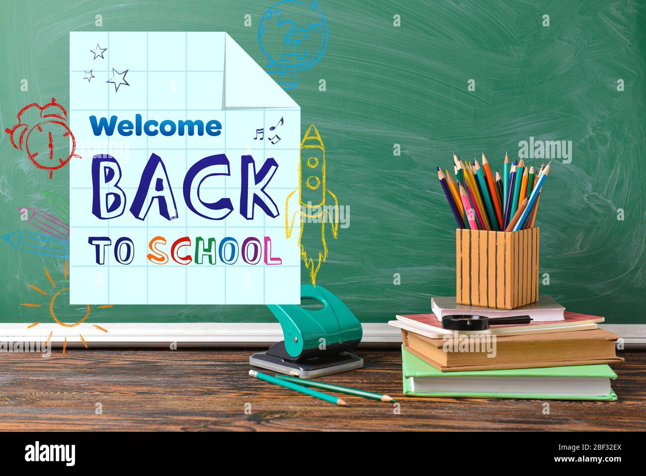 Set of school supplies on table in classroom Stock Photo - Alamy