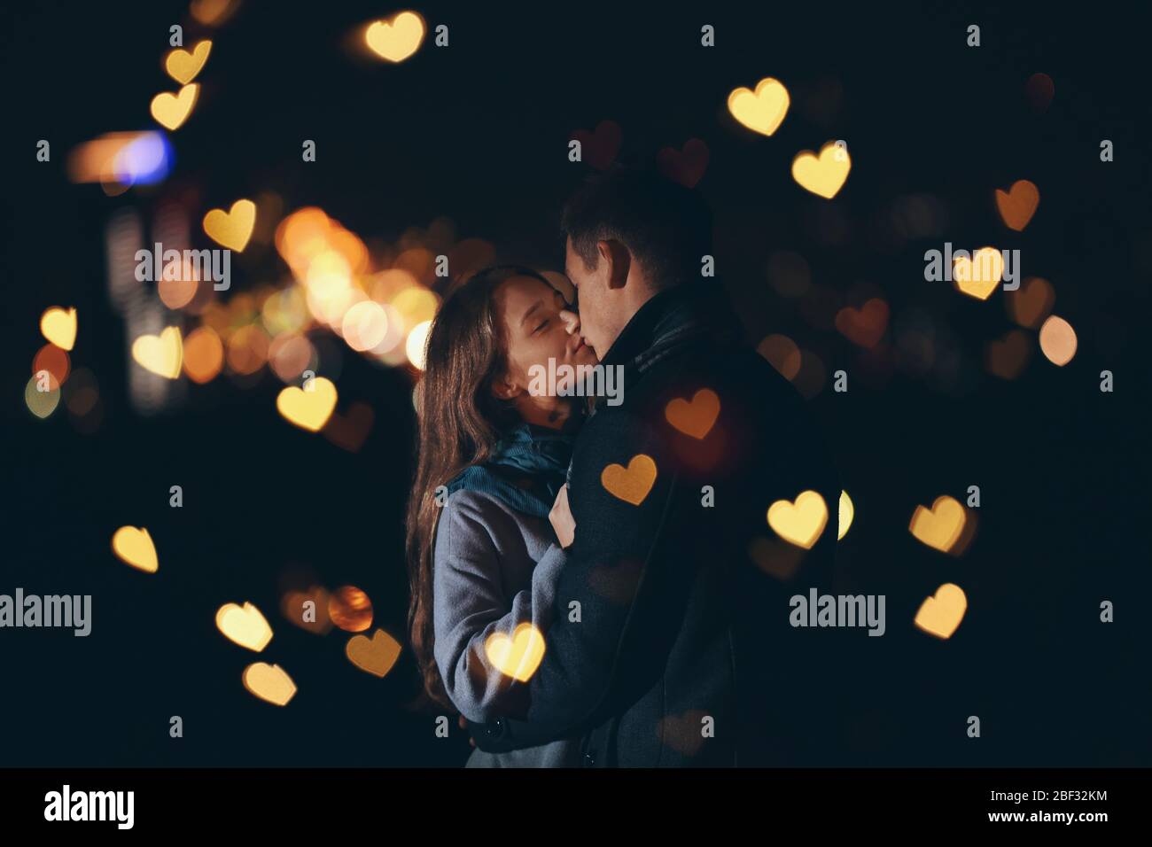 Loving young couple kissing on romantic date at night Stock Photo - Alamy