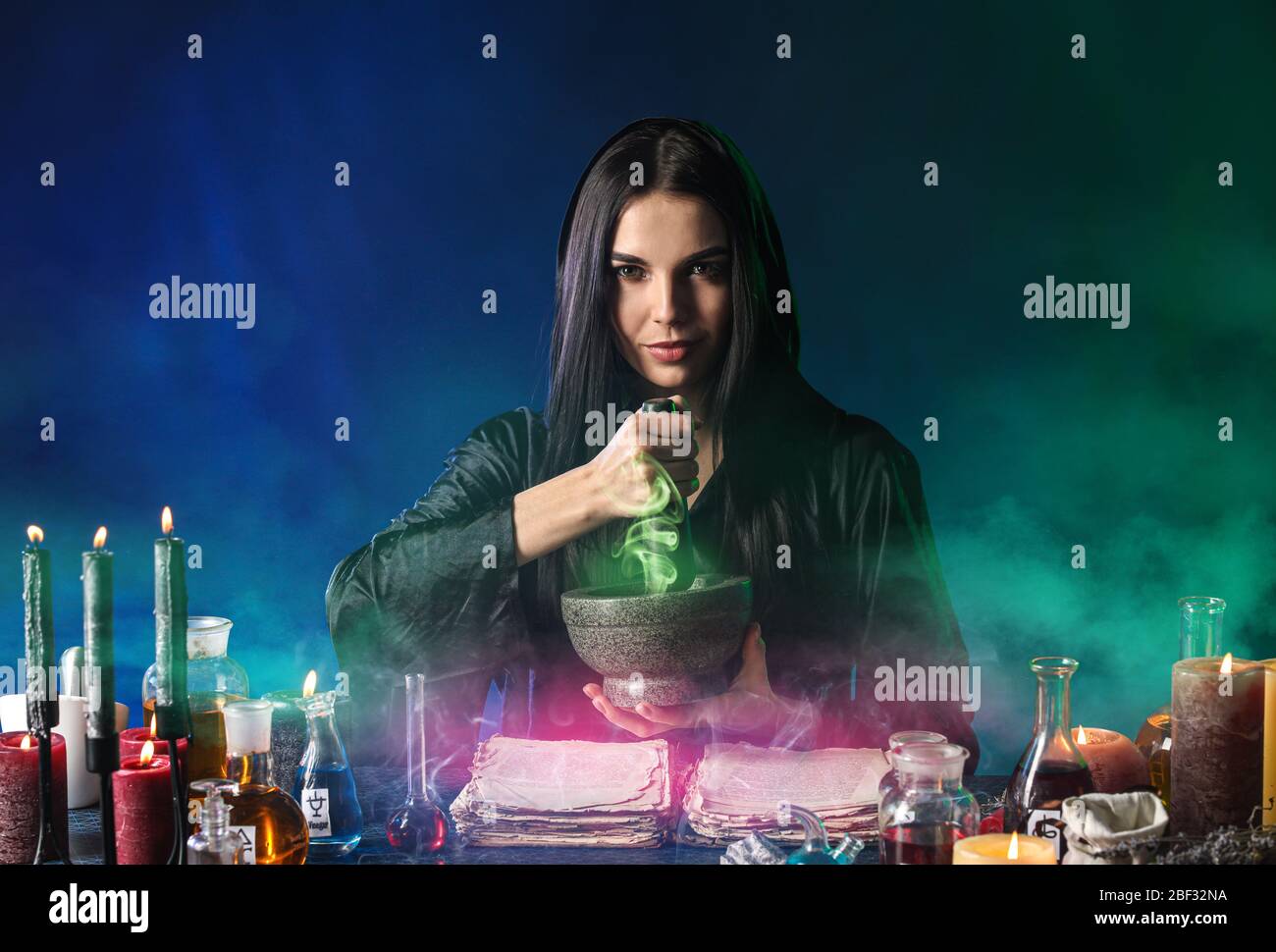 Female alchemist making potion on dark background Stock Photo - Alamy