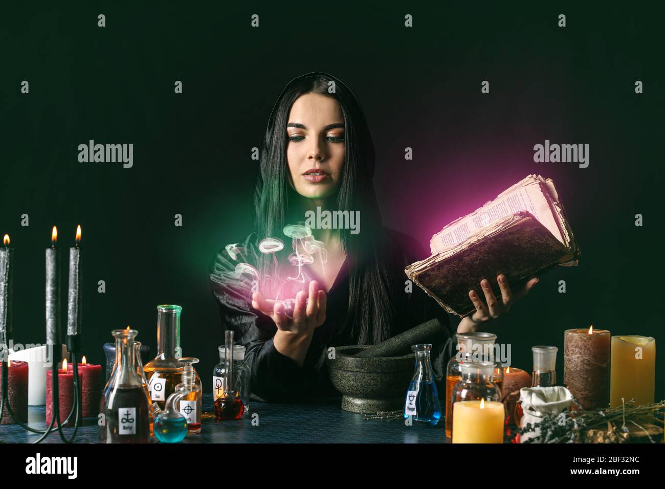 Female alchemist making potion on dark background Stock Photo - Alamy
