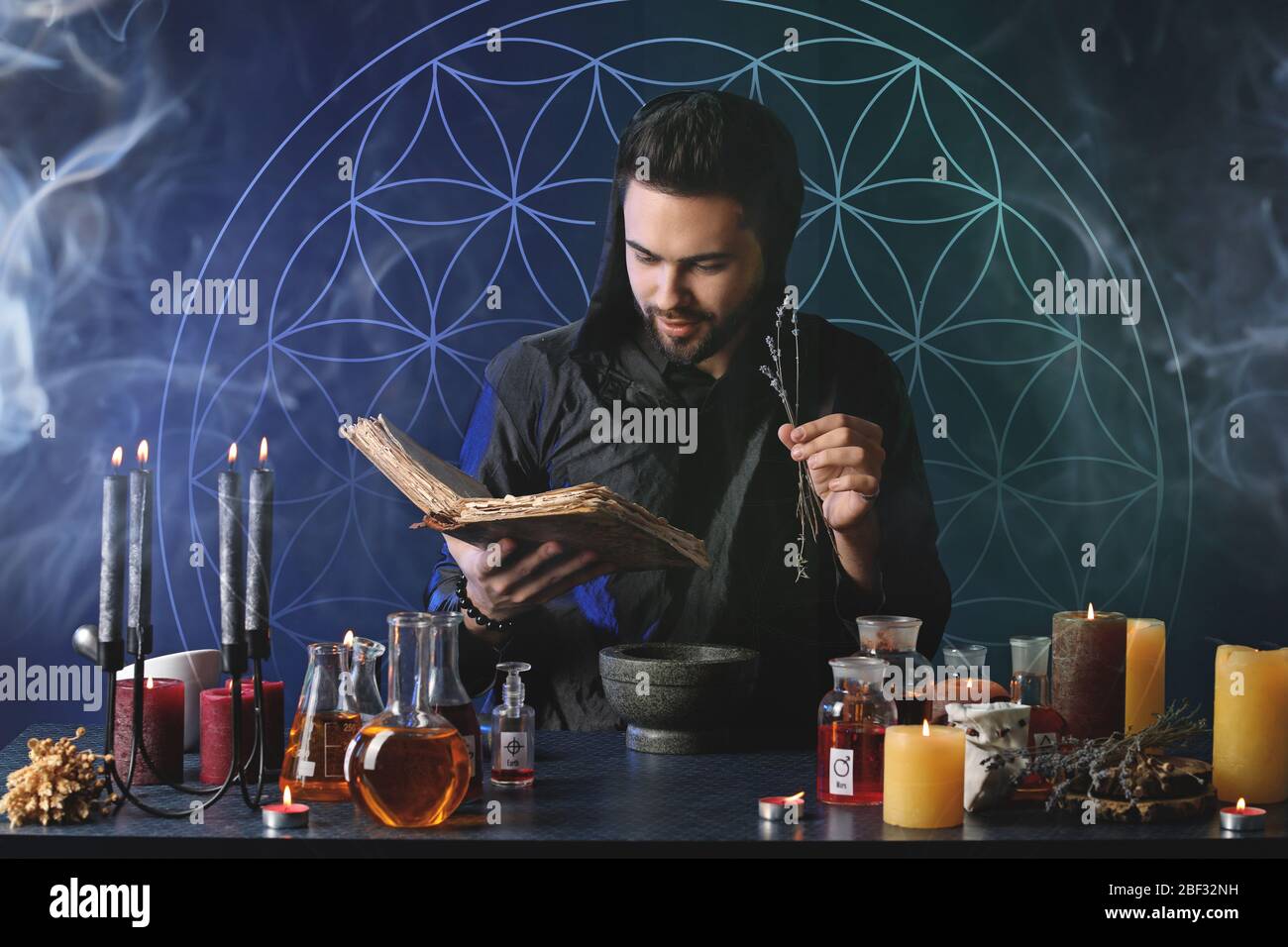 Male alchemist making potion on dark background Stock Photo - Alamy