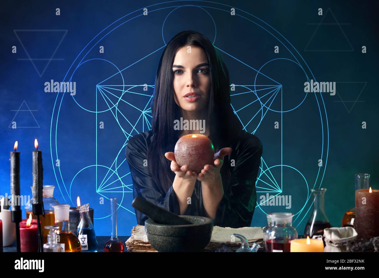 Female alchemist making potion on dark background Stock Photo - Alamy