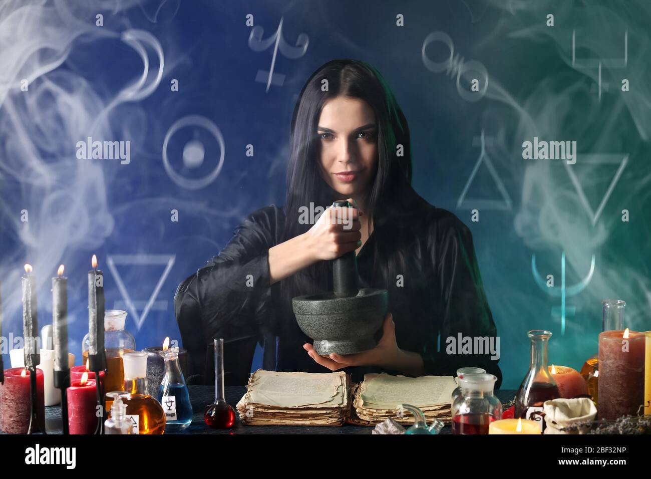 Female alchemist making potion on dark background Stock Photo - Alamy