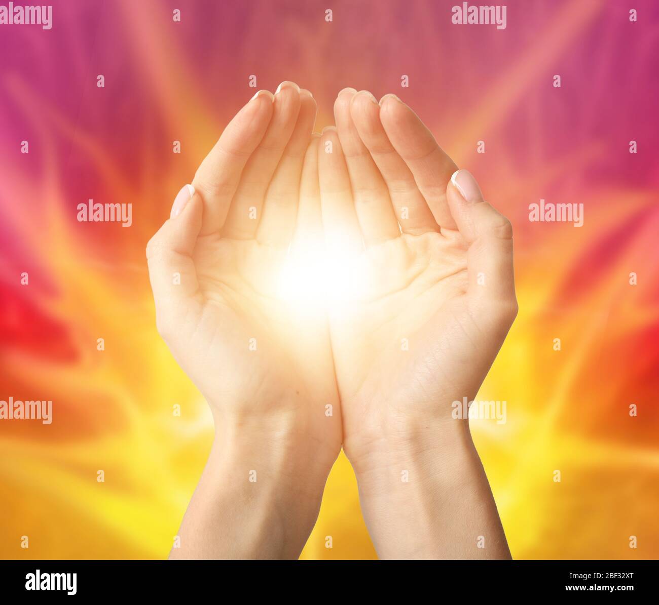 Female hands with shining energy on color background Stock Photo - Alamy