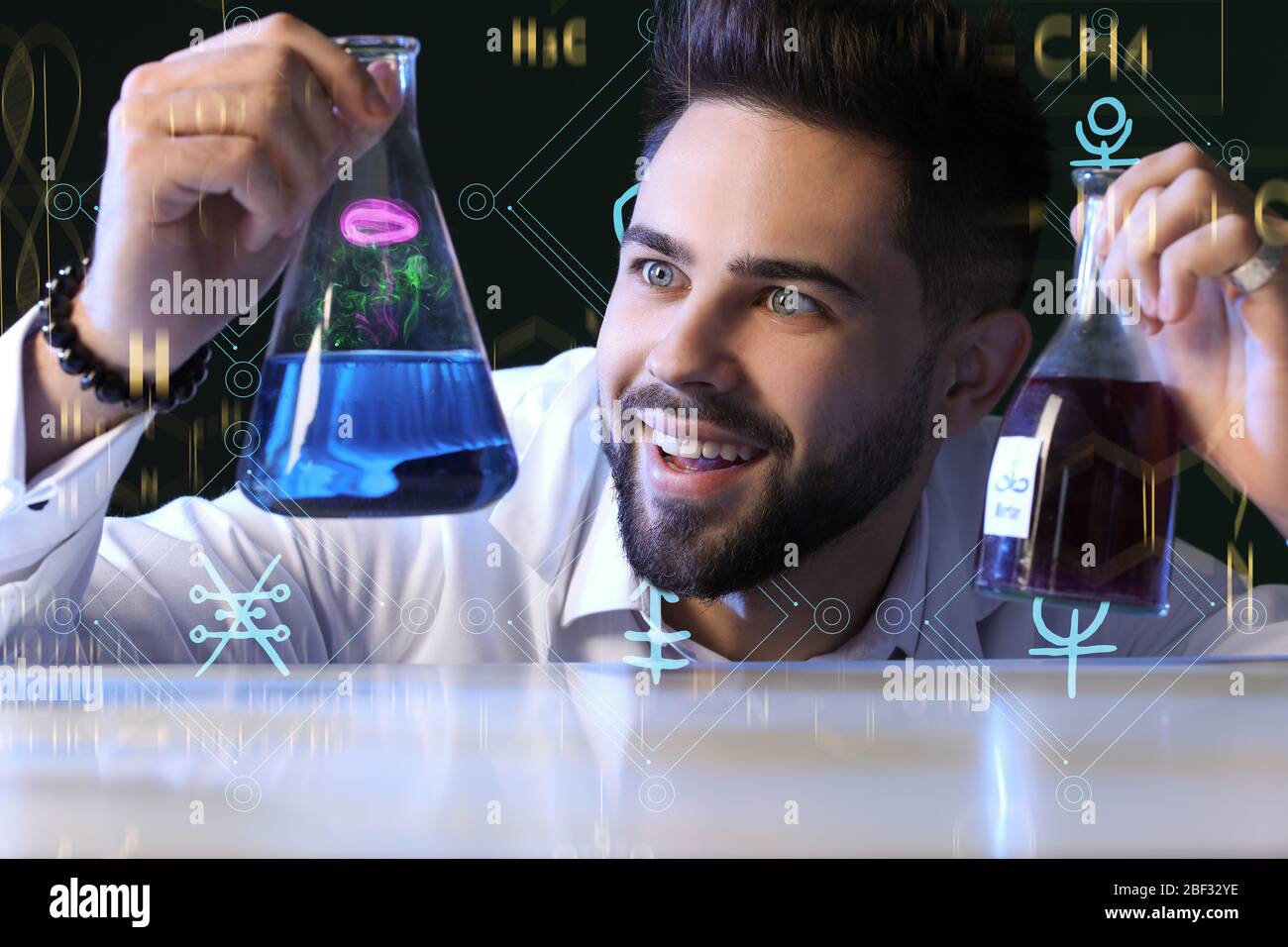 Crazy male alchemist with potions in laboratory Stock Photo - Alamy