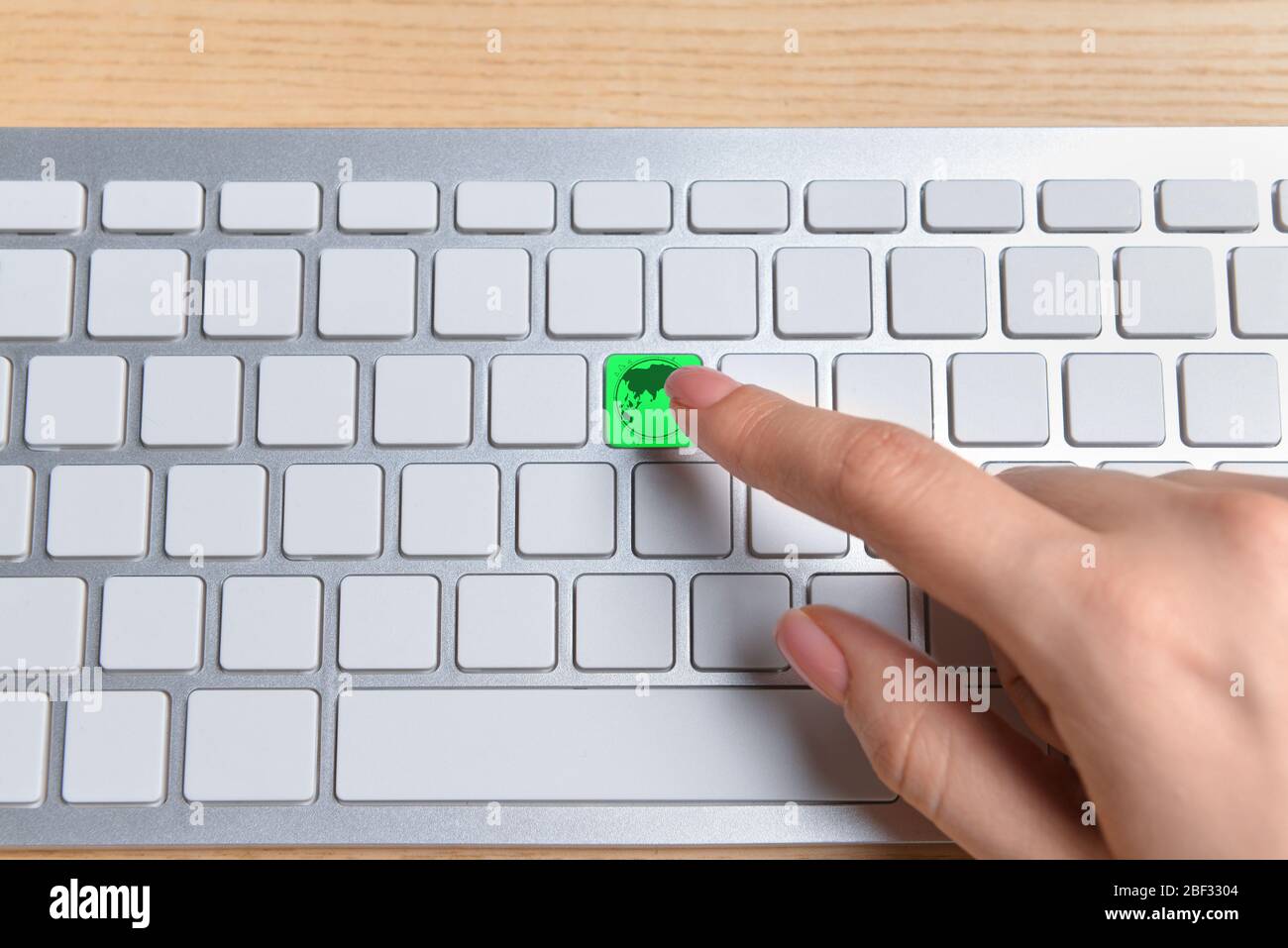 Woman pressing key with drawing of planet on PC keyboard. Earth Day ...