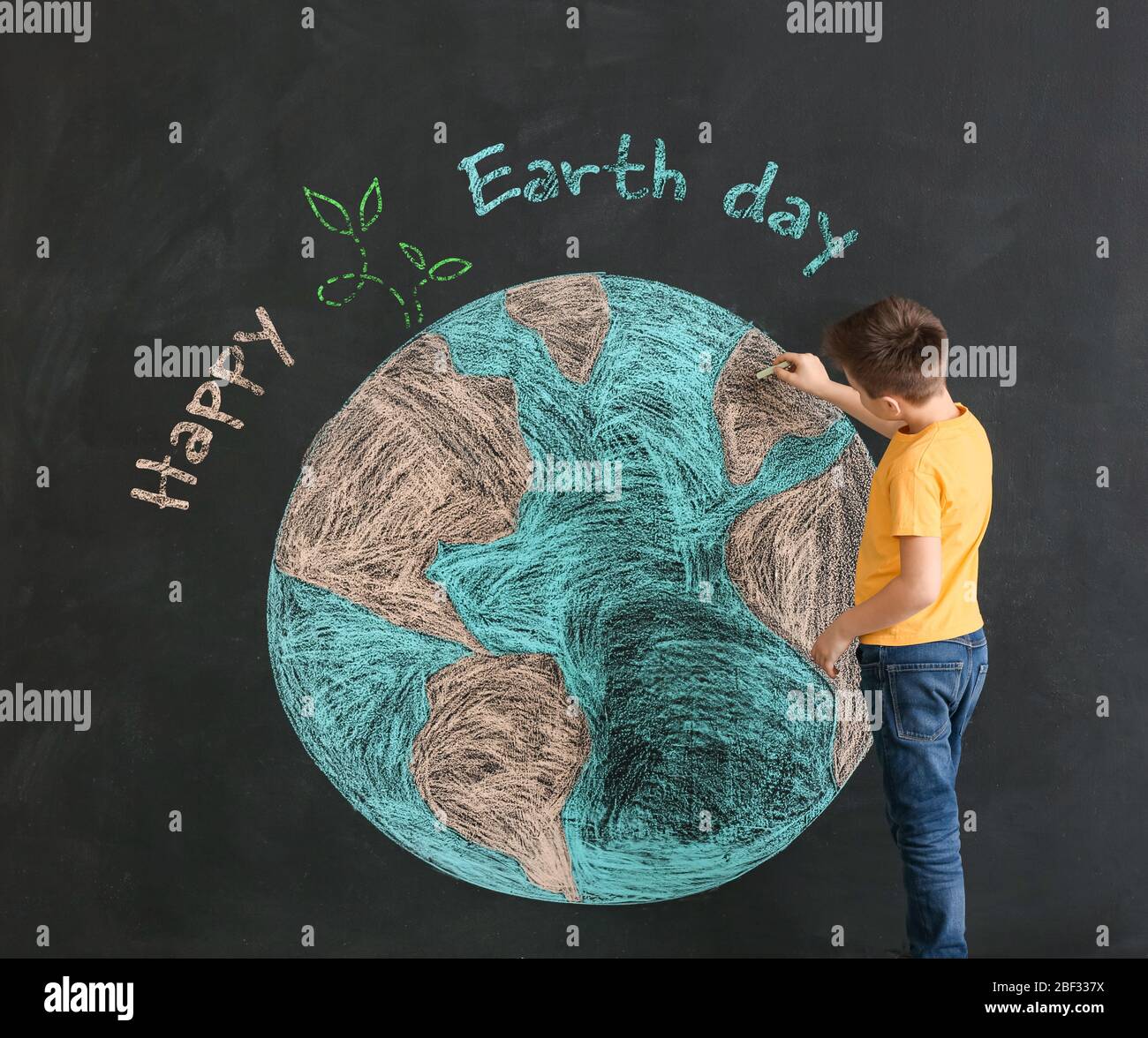 Little boy drawing planet on dark background. Earth Day celebration ...