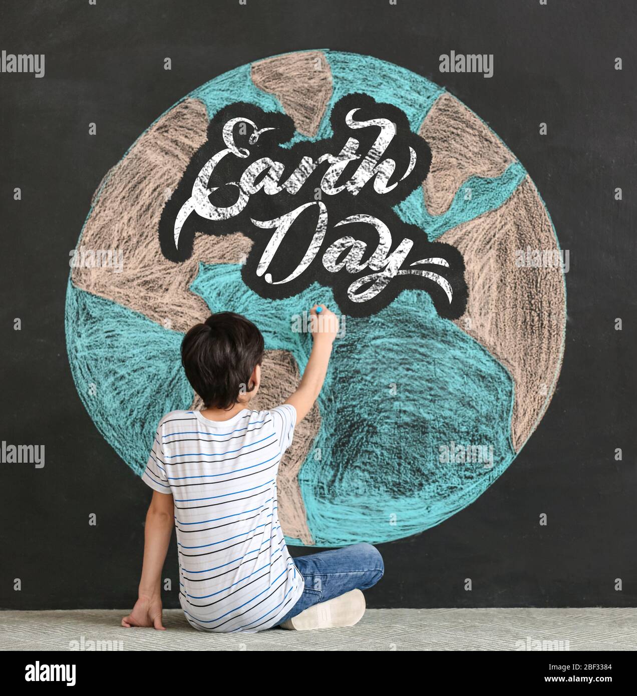 Little boy drawing planet on dark background. Earth Day celebration ...