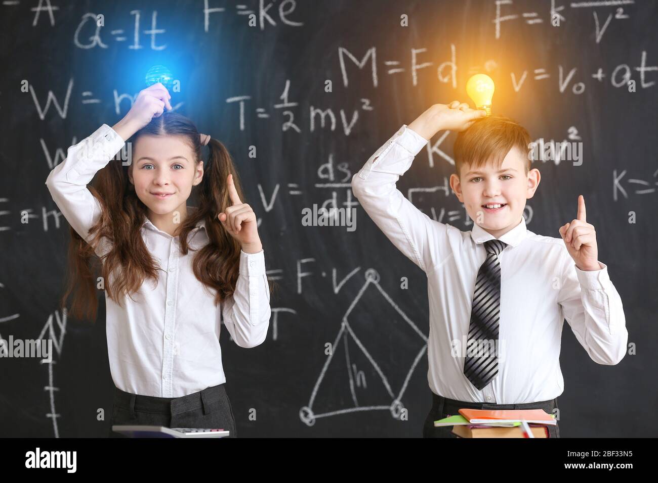 Cute little children with glowing light bulbs near blackboard at ...