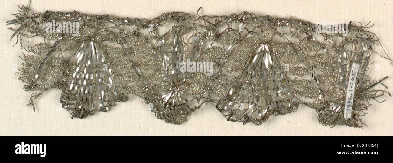 Trimming. Metallic wrapped white thread and strips of metal in a shell ...