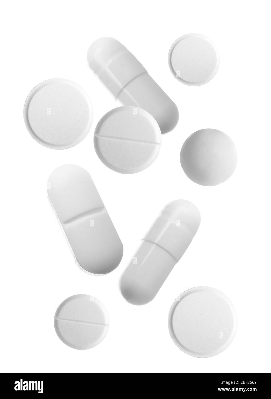 Different falling pills on white background Stock Photo - Alamy