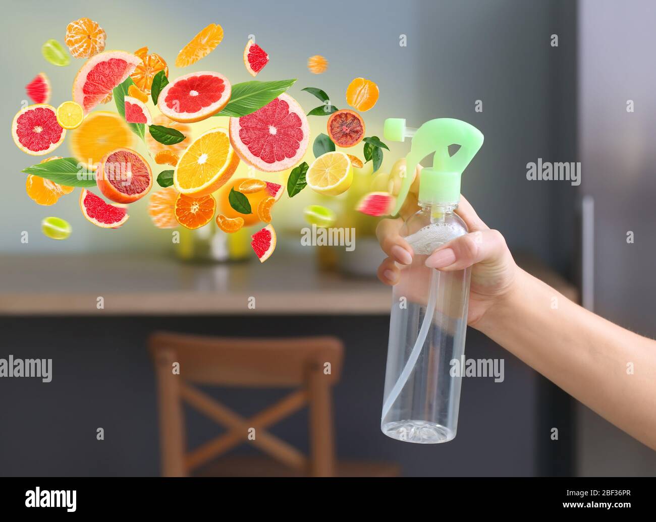 Woman spraying citrus air freshener at home Stock Photo - Alamy