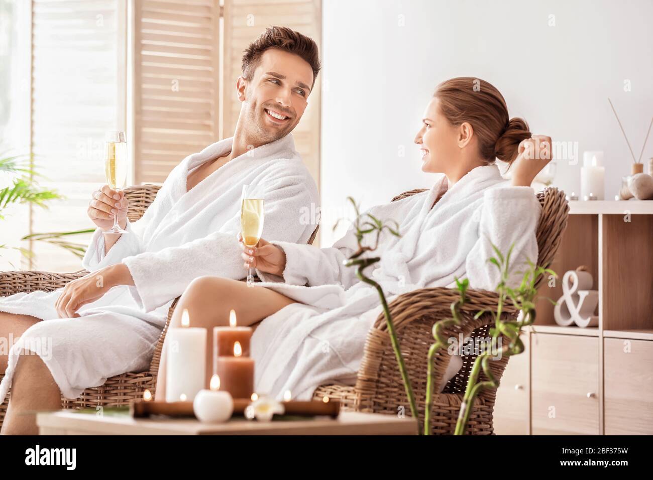 Young couple with glasses of champagne relaxing in spa salon Stock ...