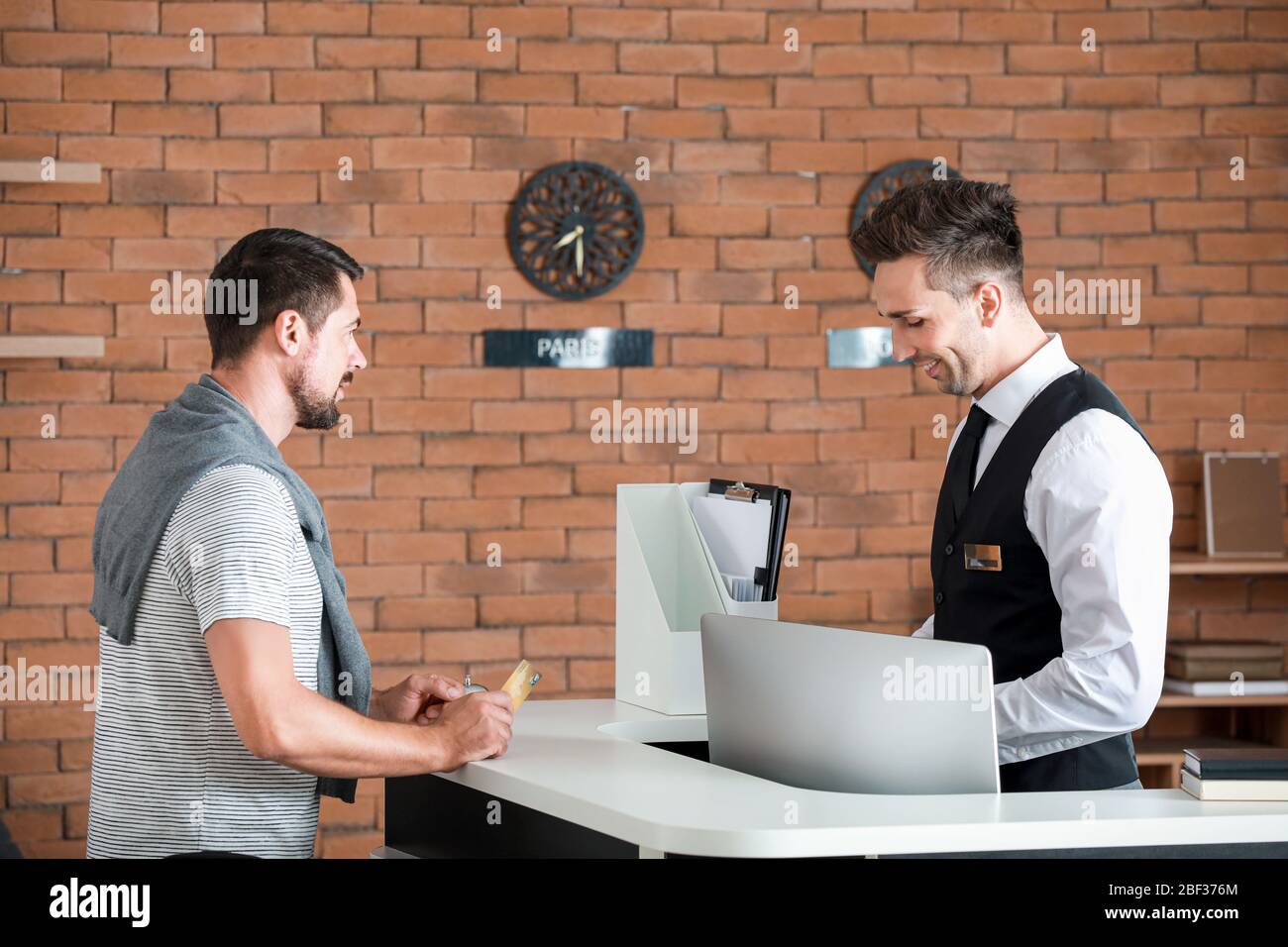 Man booking room in hotel at reception Stock Photo - Alamy