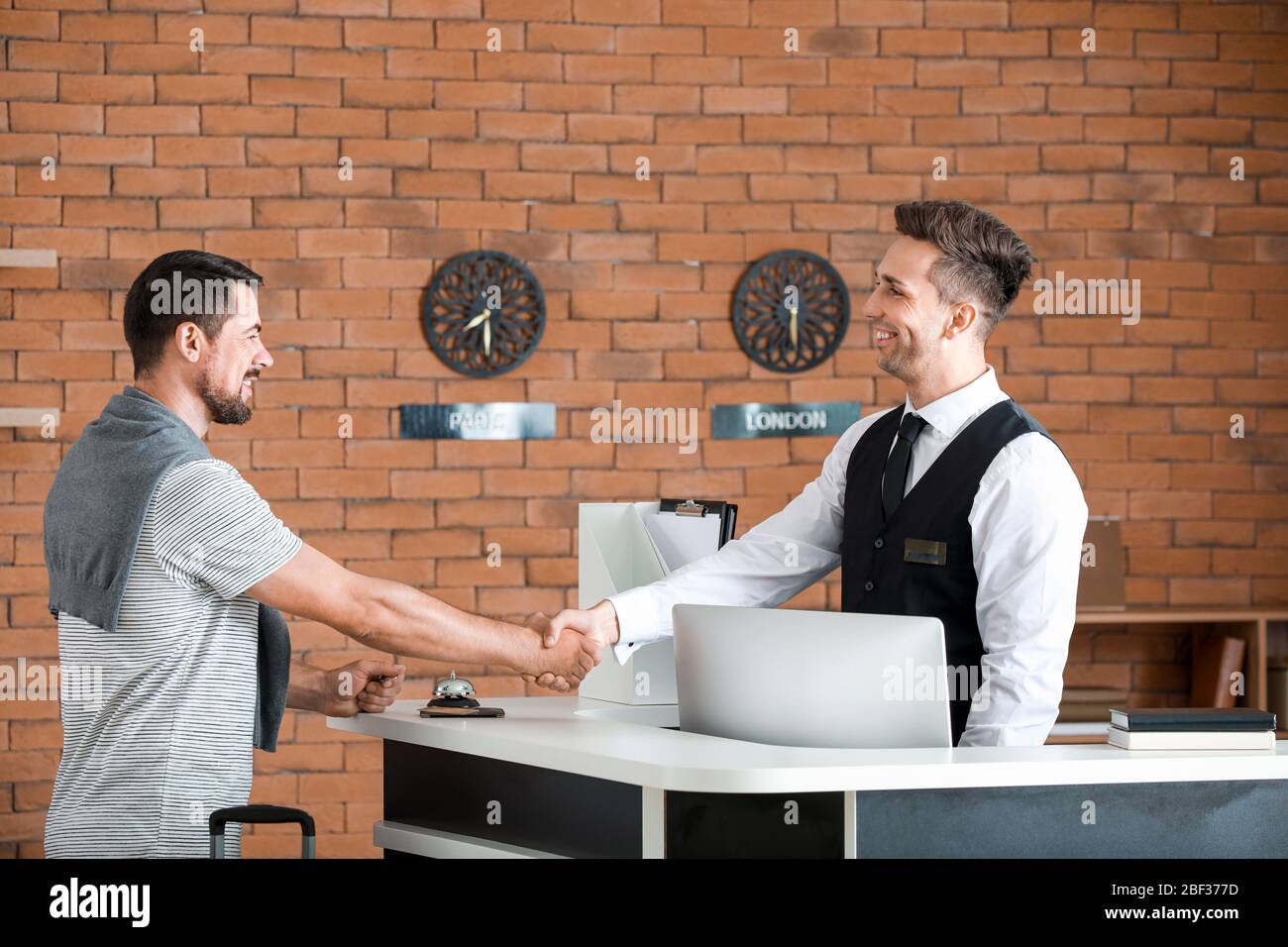 Man booking room in hotel at reception Stock Photo - Alamy
