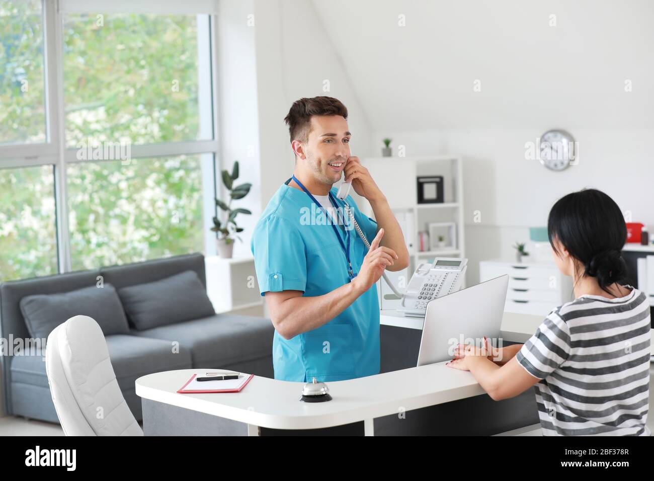Patient talking receptionist hi-res stock photography and images - Alamy