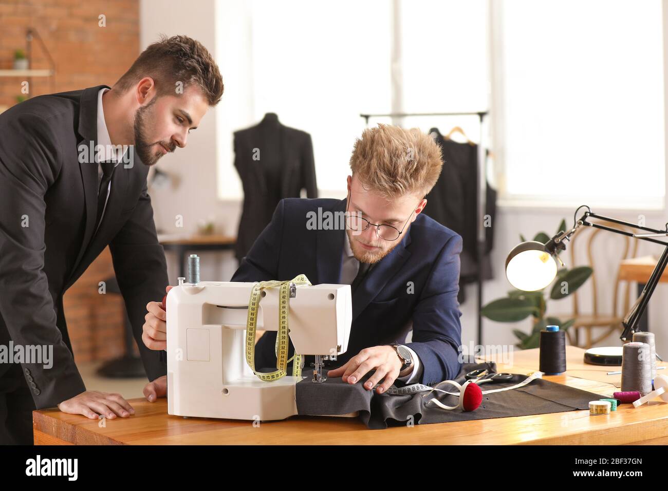 Tailor With Colleague Working In Sewing Workshop High Resolution Stock ...