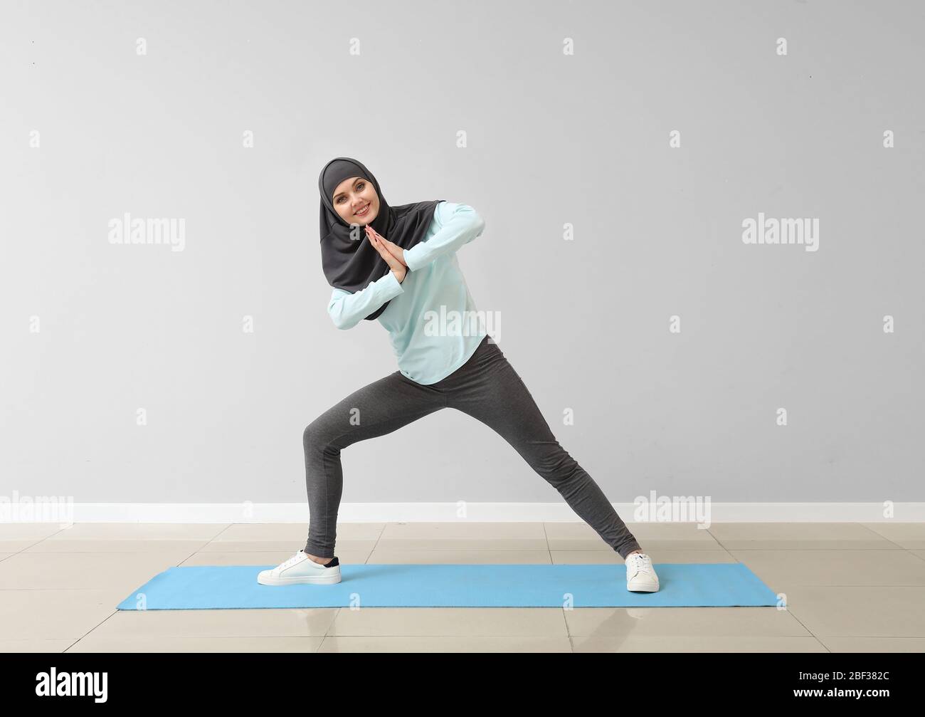 Sporty Muslim woman practicing yoga in gym Stock Photo - Alamy