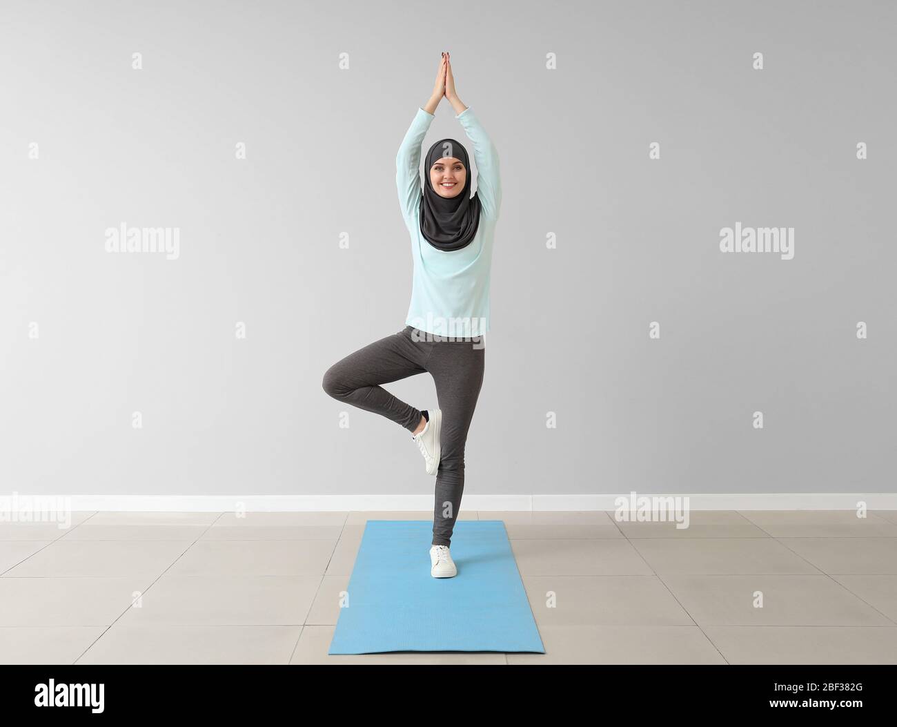 Sporty Muslim woman practicing yoga in gym Stock Photo - Alamy