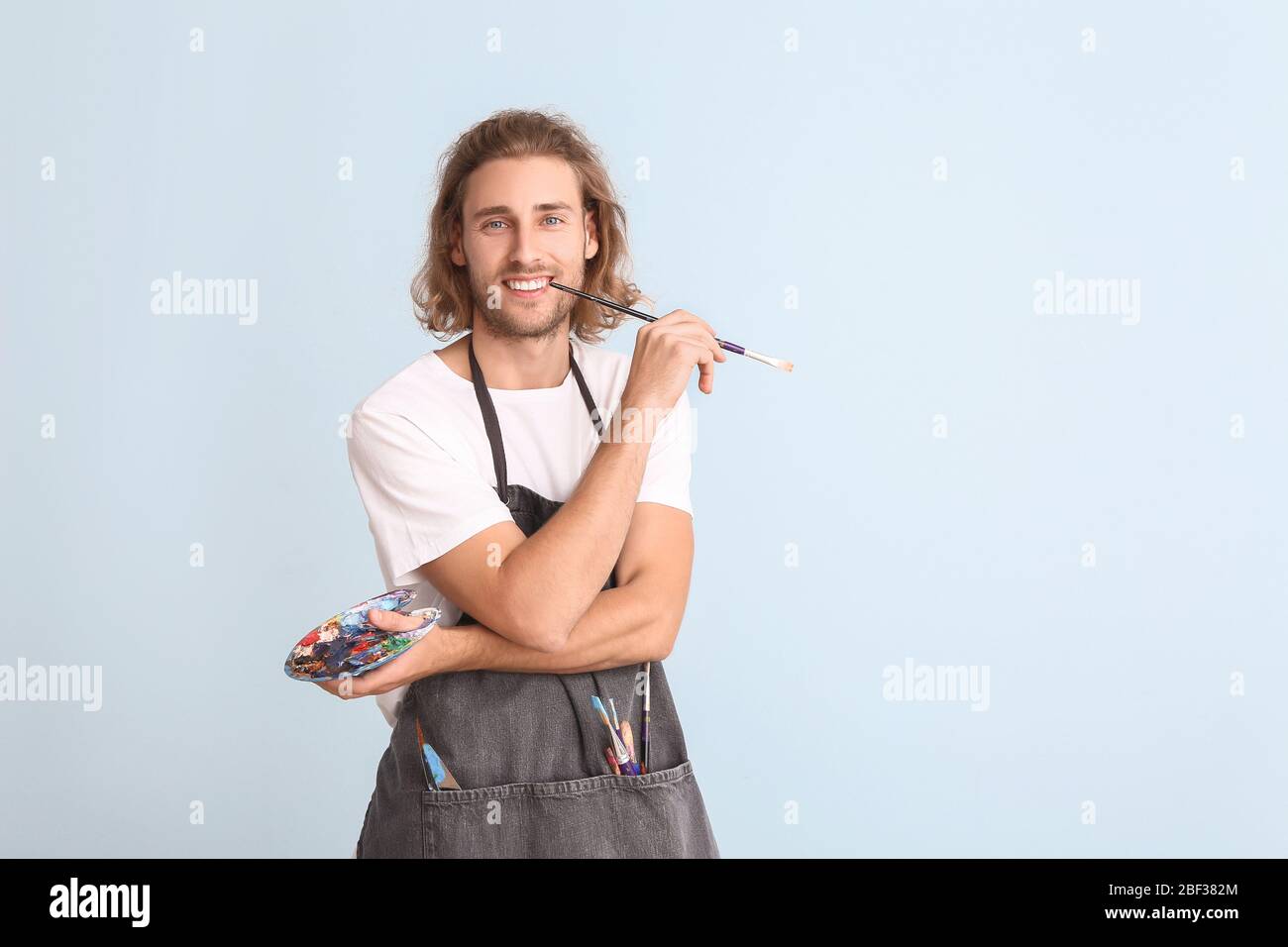 Portrait of young male artist on color background Stock Photo - Alamy