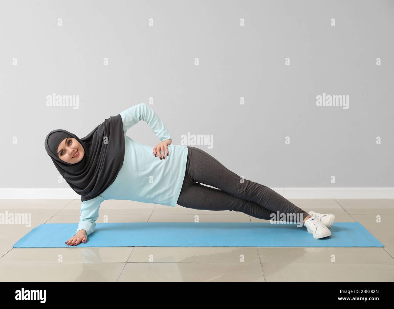 Sporty Muslim woman practicing yoga in gym Stock Photo - Alamy