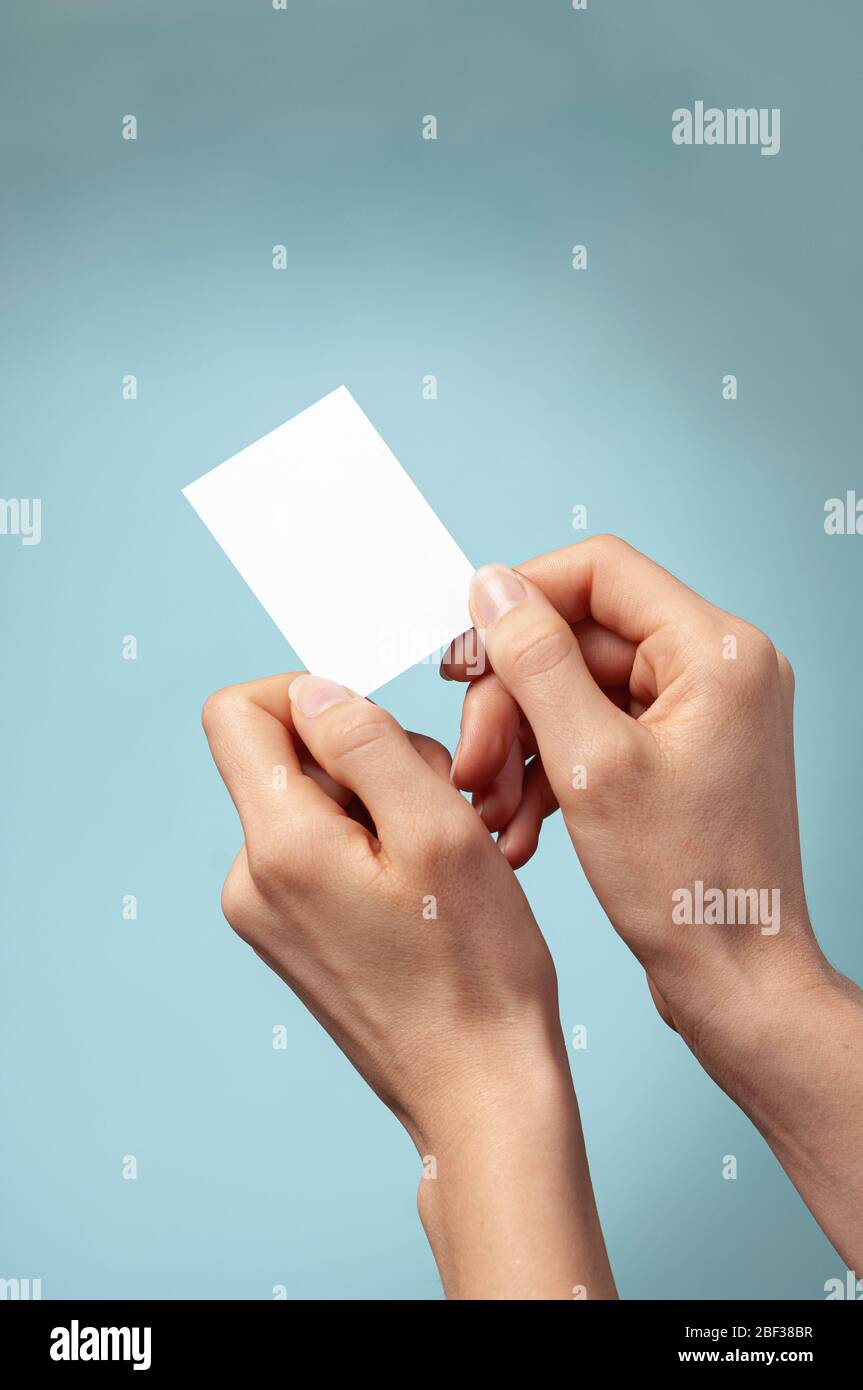 Woman holding small blank white note paper with two hands, vertical ...