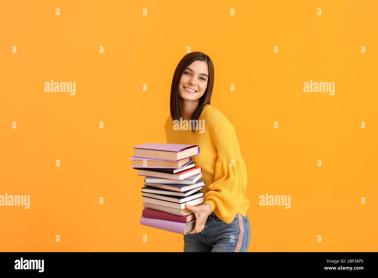 Beautiful young woman with many books on color background Stock Photo ...