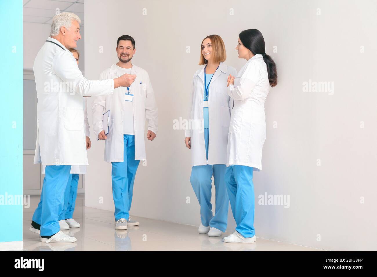 Doctors discussing something in hall of clinic Stock Photo - Alamy