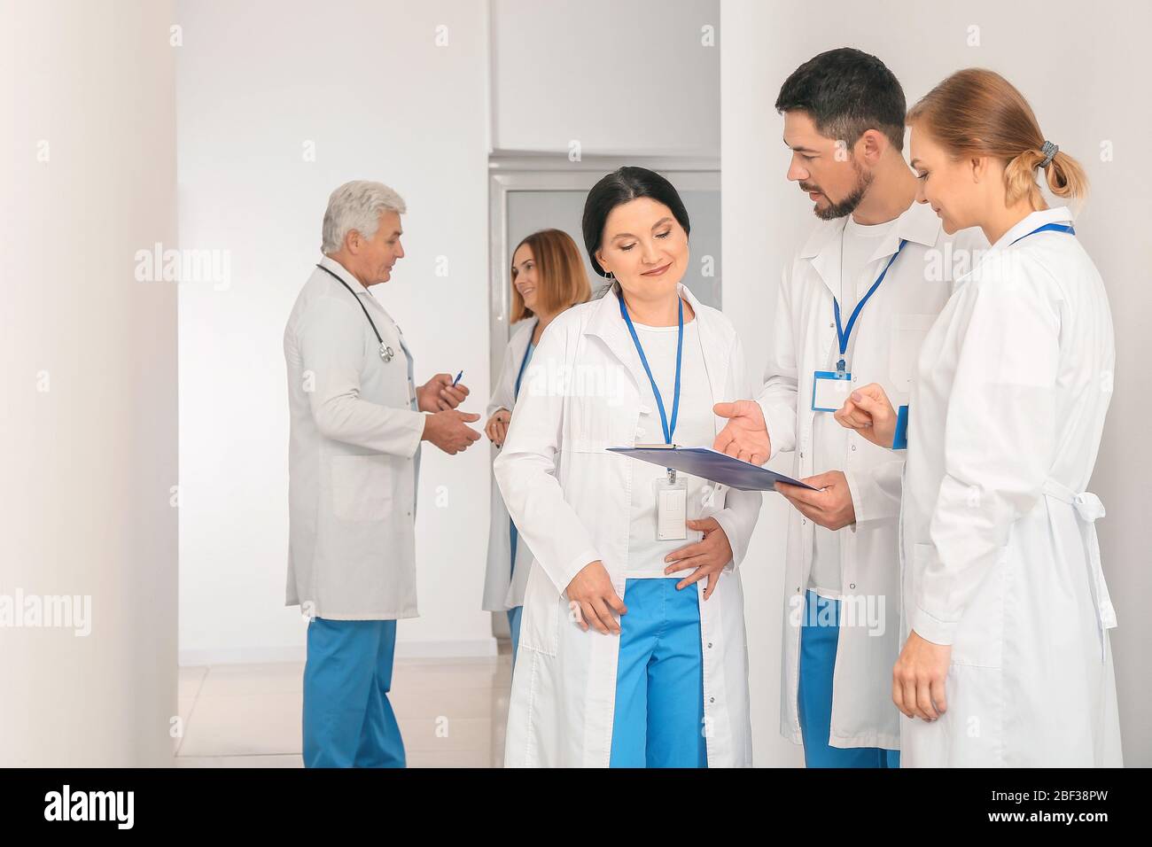 Doctors discussing something in hall of clinic Stock Photo - Alamy