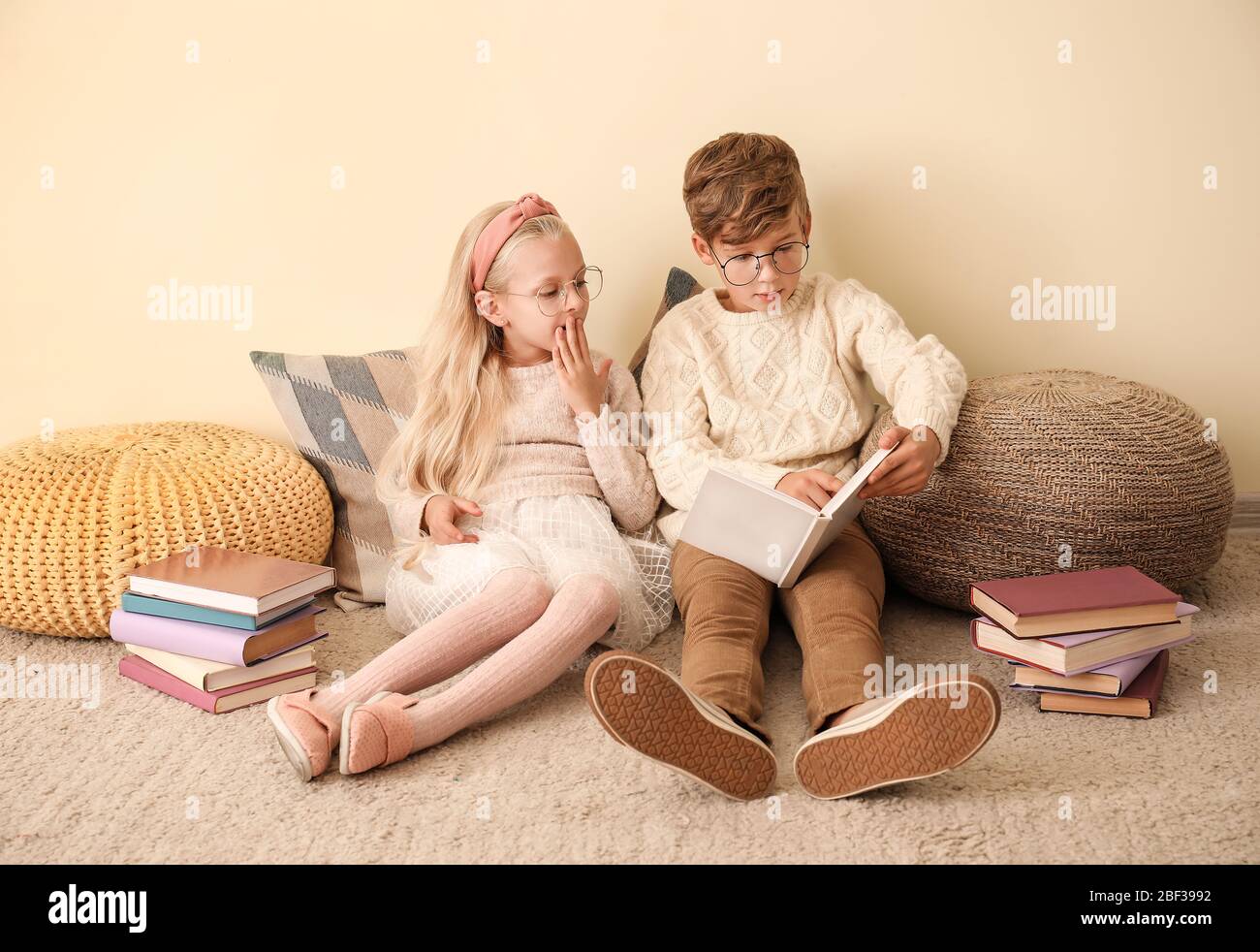 Little children reading books near color wall Stock Photo - Alamy