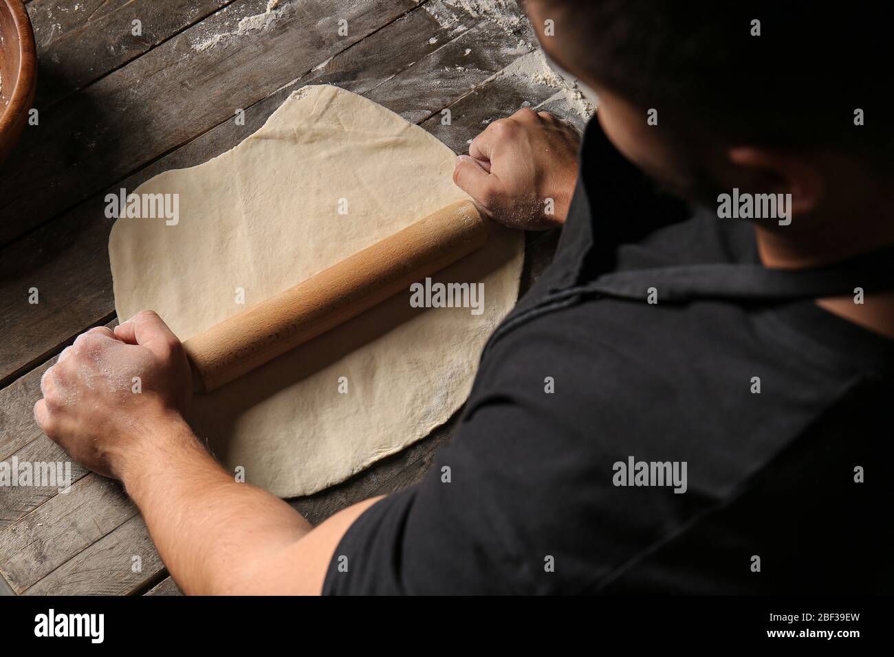 Man rolling out dough in kitchen Stock Photo - Alamy