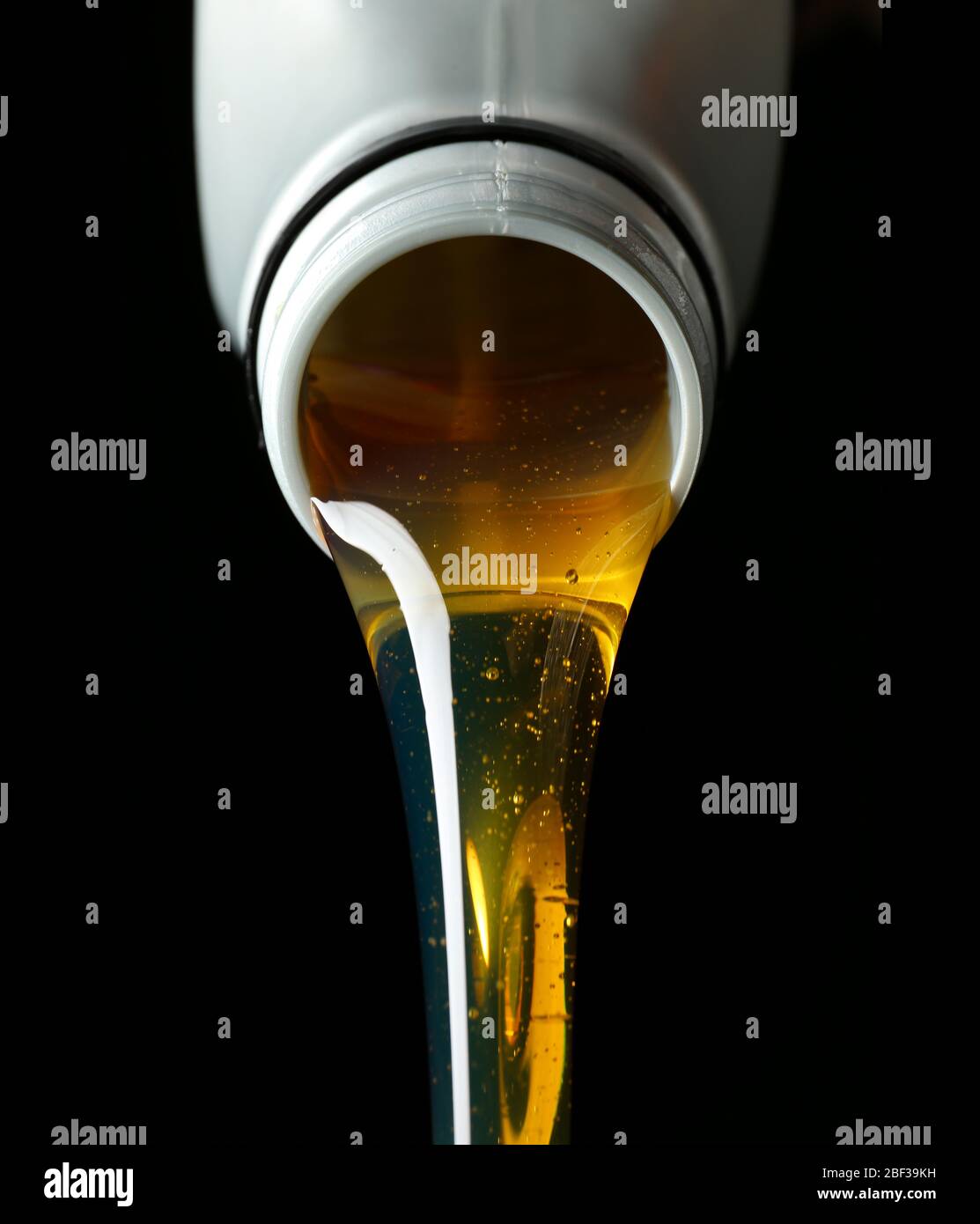 Pouring car oil on dark background, closeup Stock Photo - Alamy