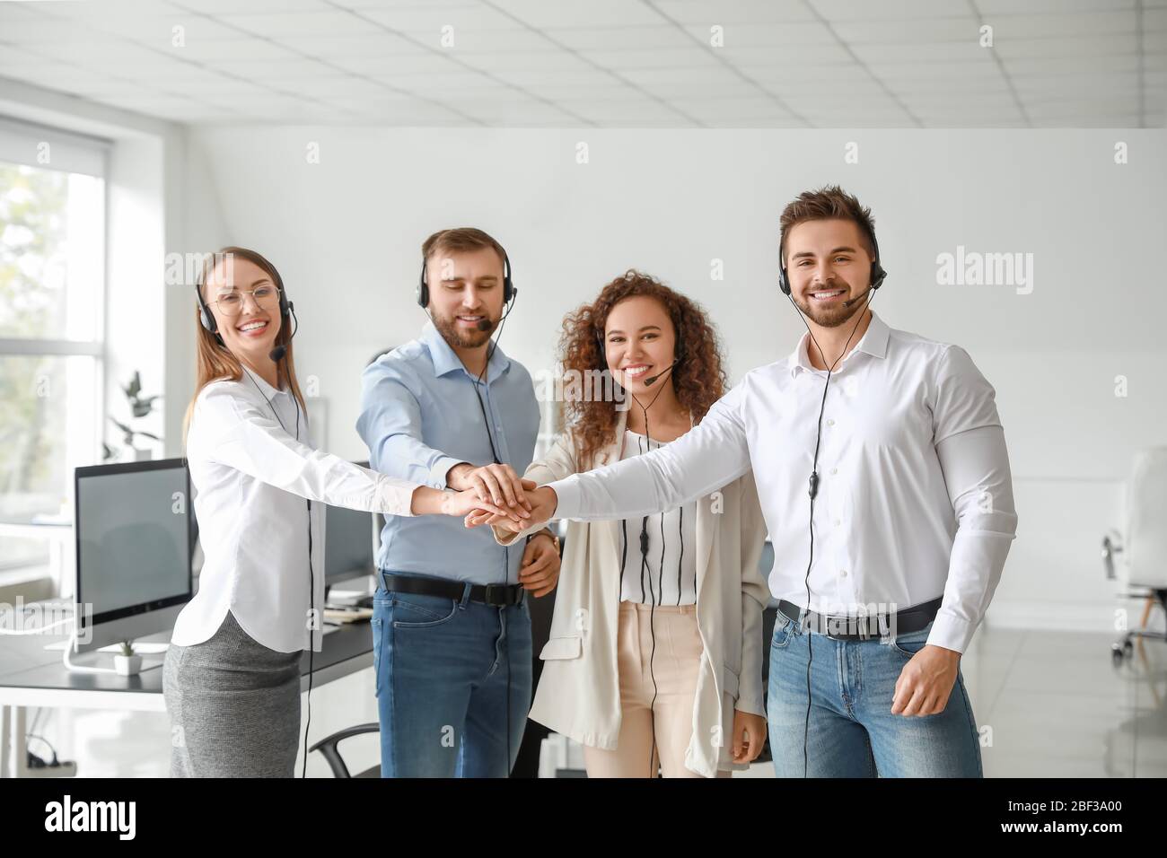 Technical support agents putting hands together in office Stock Photo ...